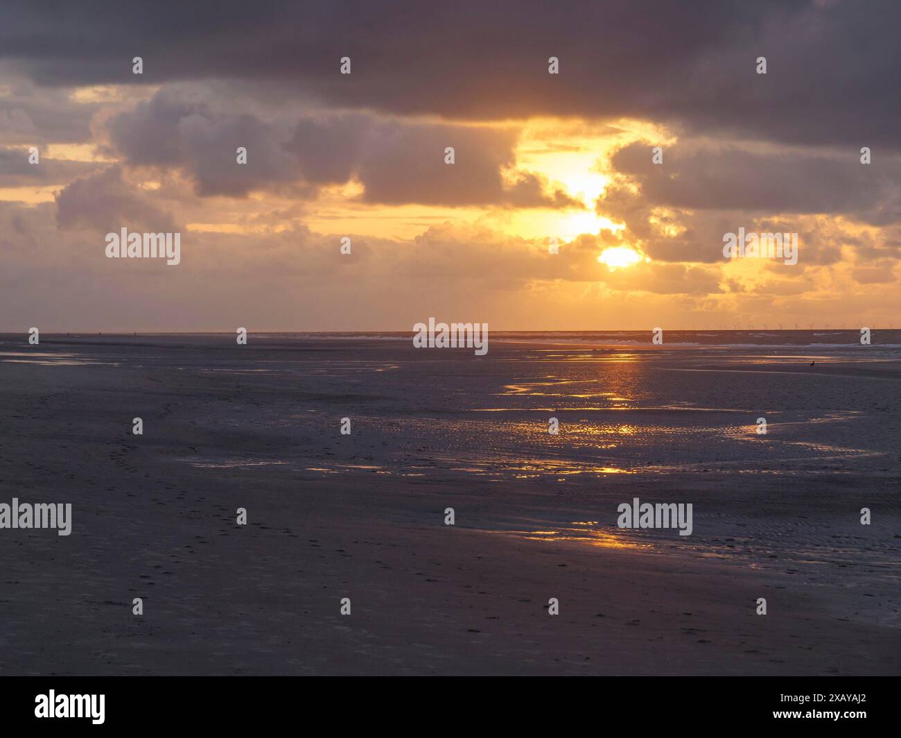 Melancholic sunset on the beach with footprints in the sand and golden ...