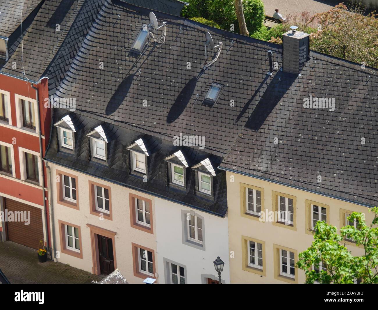 House roofs in an urban area with skylights and satellite dishes ...