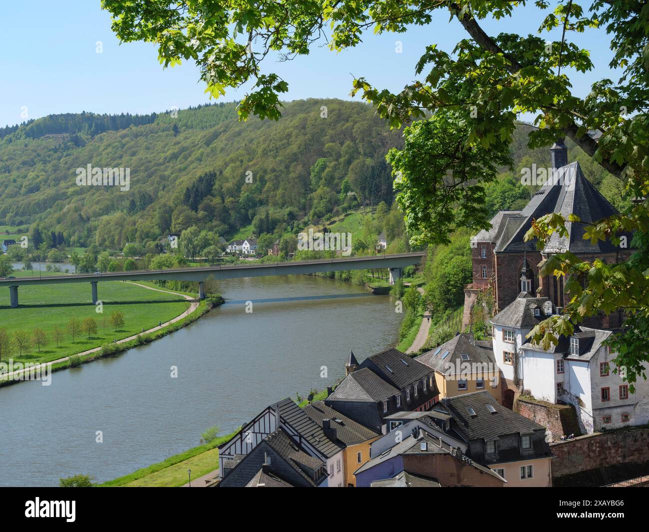 View of a river with a bridge, neighbouring houses and a church in a ...