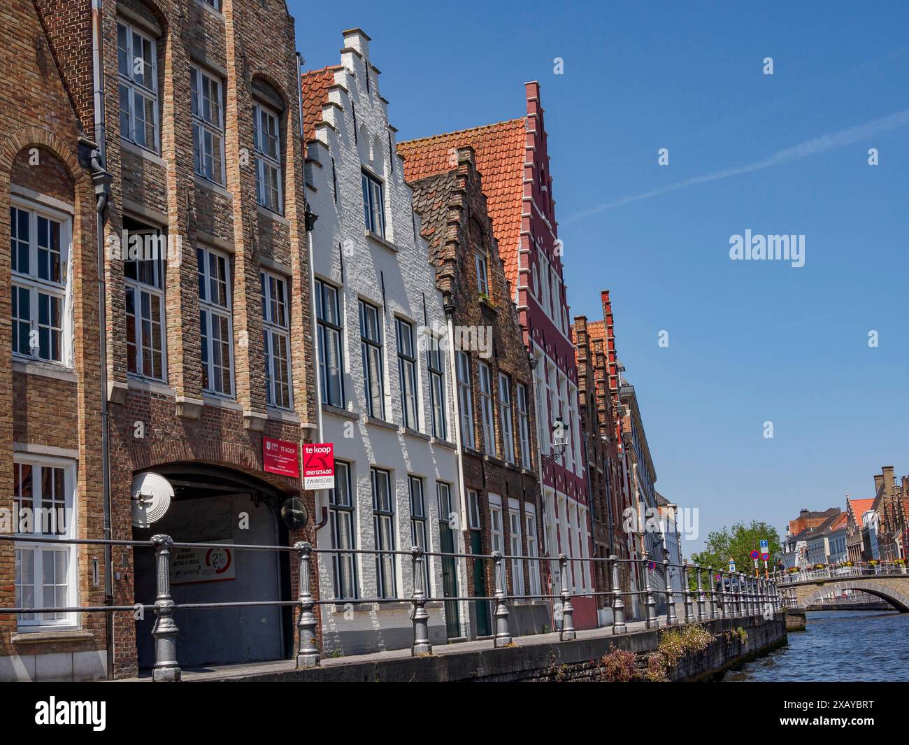 Row of traditional canal-side buildings under a clear blue sky with ...