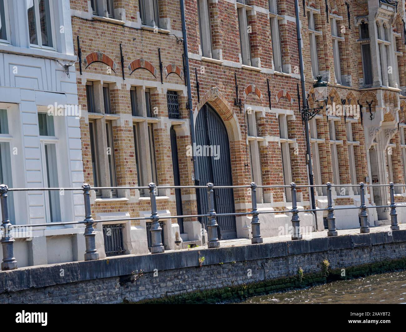Detailed historic brick facade with large windows and a wrought-iron ...