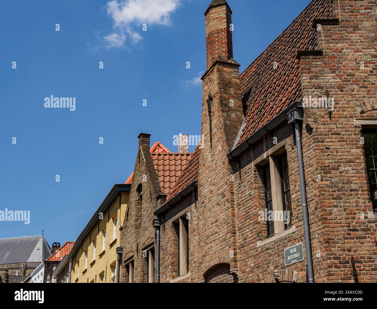 Admire historic brick houses with tiled roofs under a clear blue sky ...