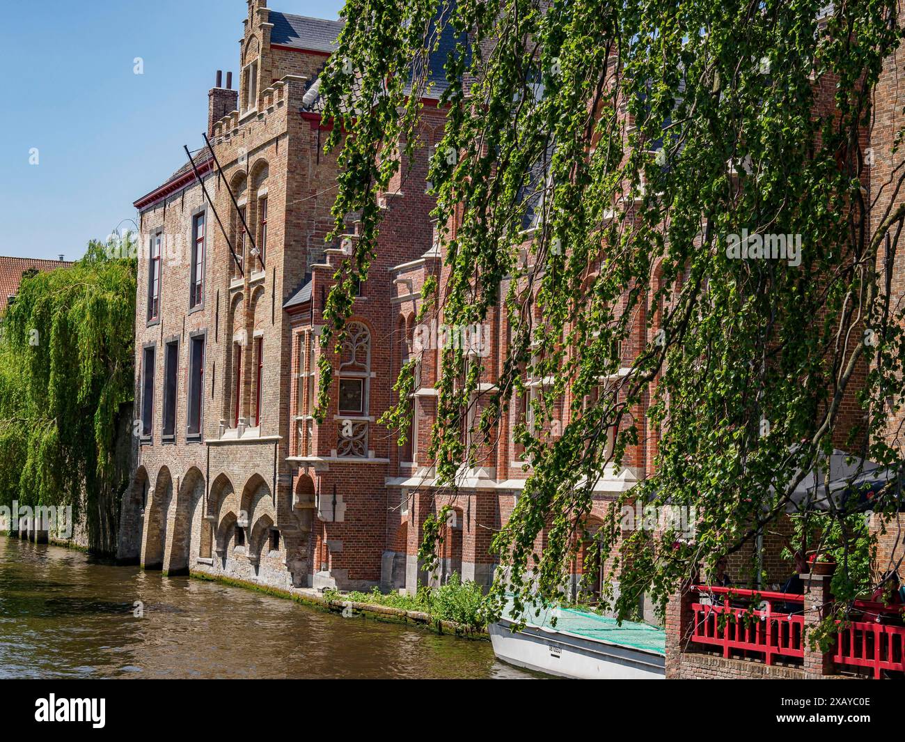 Historic brick buildings on the banks of a canal, partially concealed ...