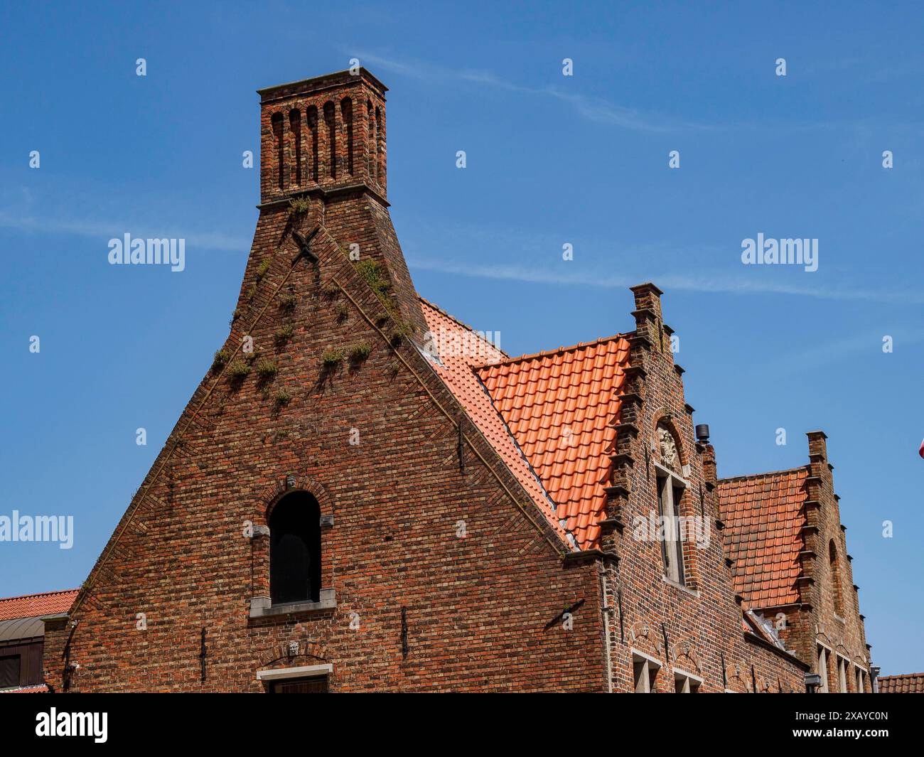 Historic building with striking brick gable and chimney, under a clear ...