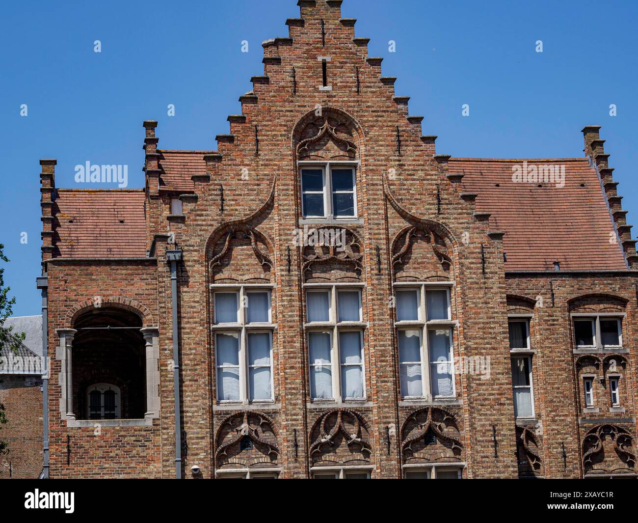Gothic brick building with richly decorated windows and tiled roof ...