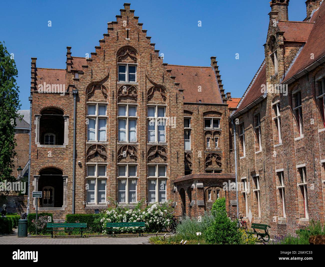 A historic building with ornate windows and entrances, set in a garden ...