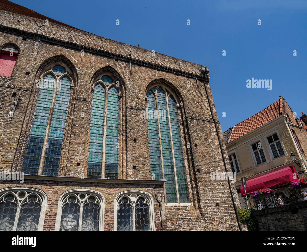 Large brick building with high pointed arch windows and clear blue sky ...