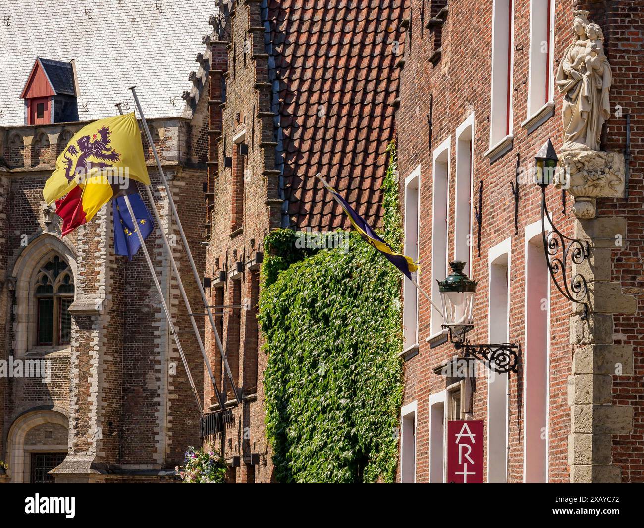 Historic building with flags and a statue, covered with ivy and red ...