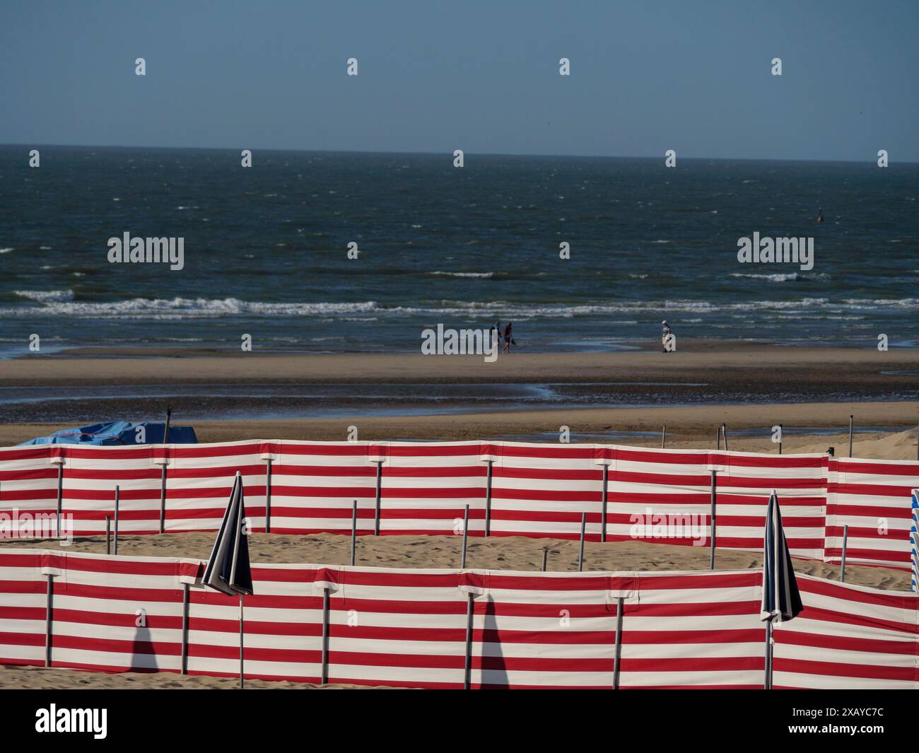 Beach with red and white barriers and a view of the sea and waves on ...