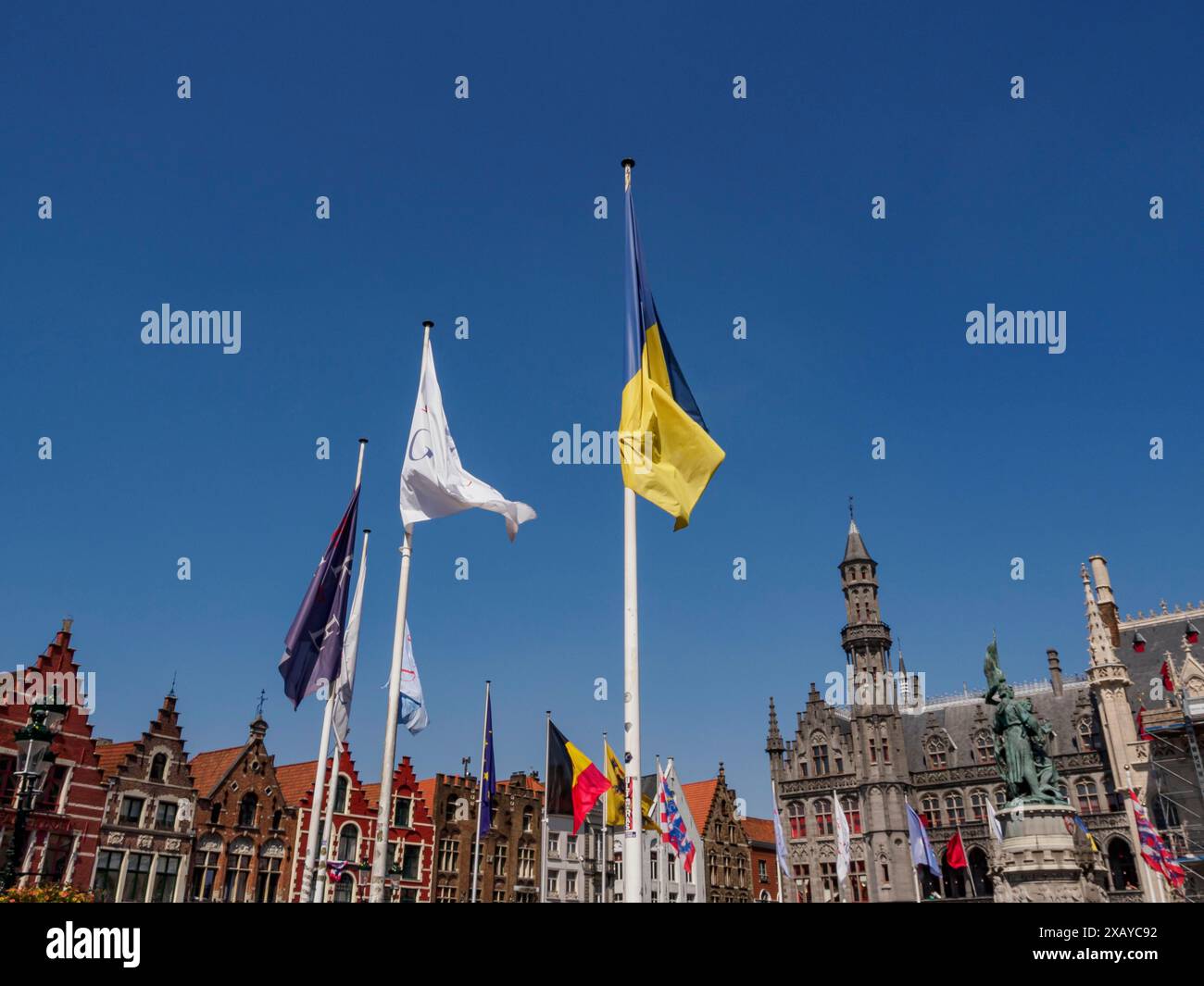 Flags waving against a backdrop of historic buildings on a sunny day ...