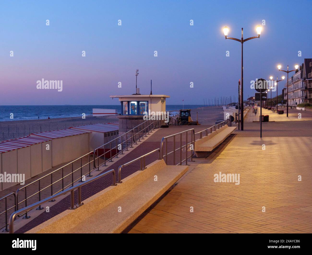 Evening beach promenade with illuminated lanterns and buildings, quiet ...