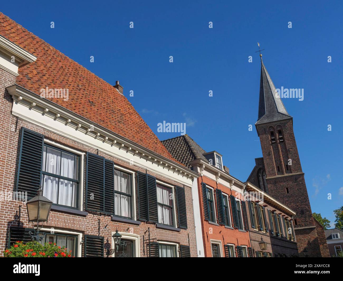 Row of houses with typical shutters and tiled roofs, next to a church ...