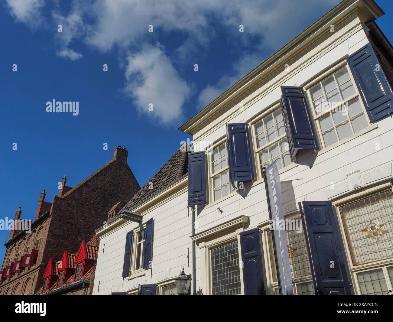 Row of houses with dominant shutters and white facade under a mostly ...