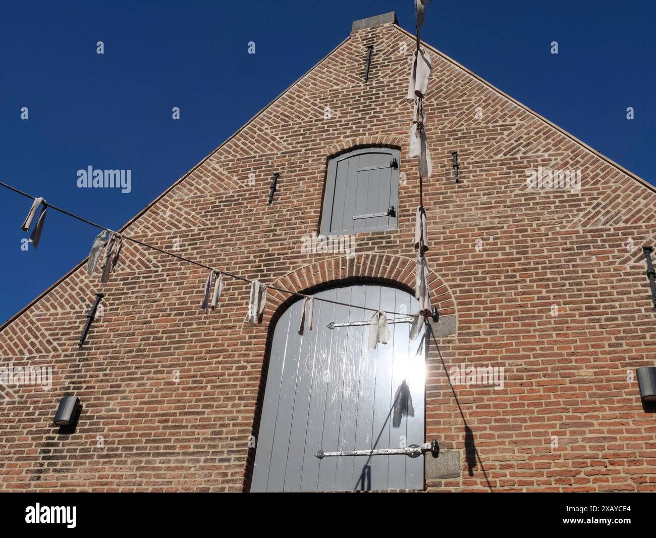 Large red brick building with grey doors and pennants hanging from ...