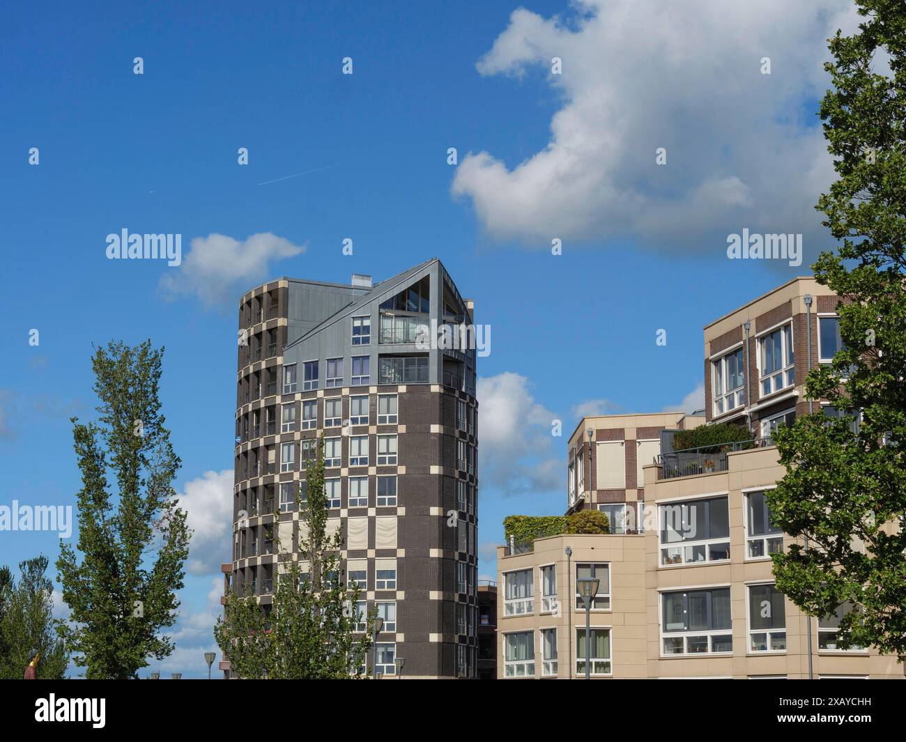 Tall, modern residential tower and neighbouring buildings in the middle ...