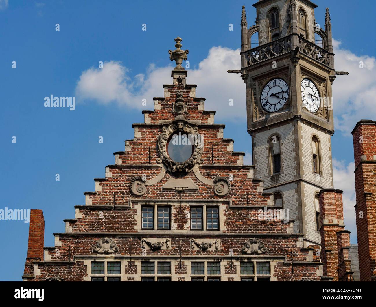 A striking clock tower and the gable of a brick house stand out against ...