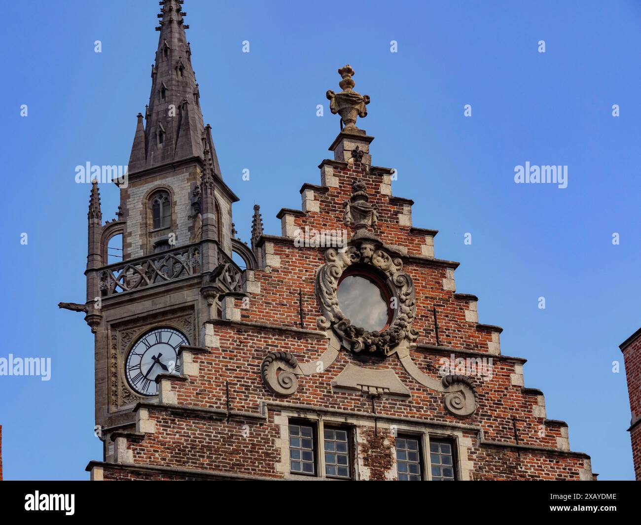 A historic bell tower with a clock and elaborate Gothic decorations ...