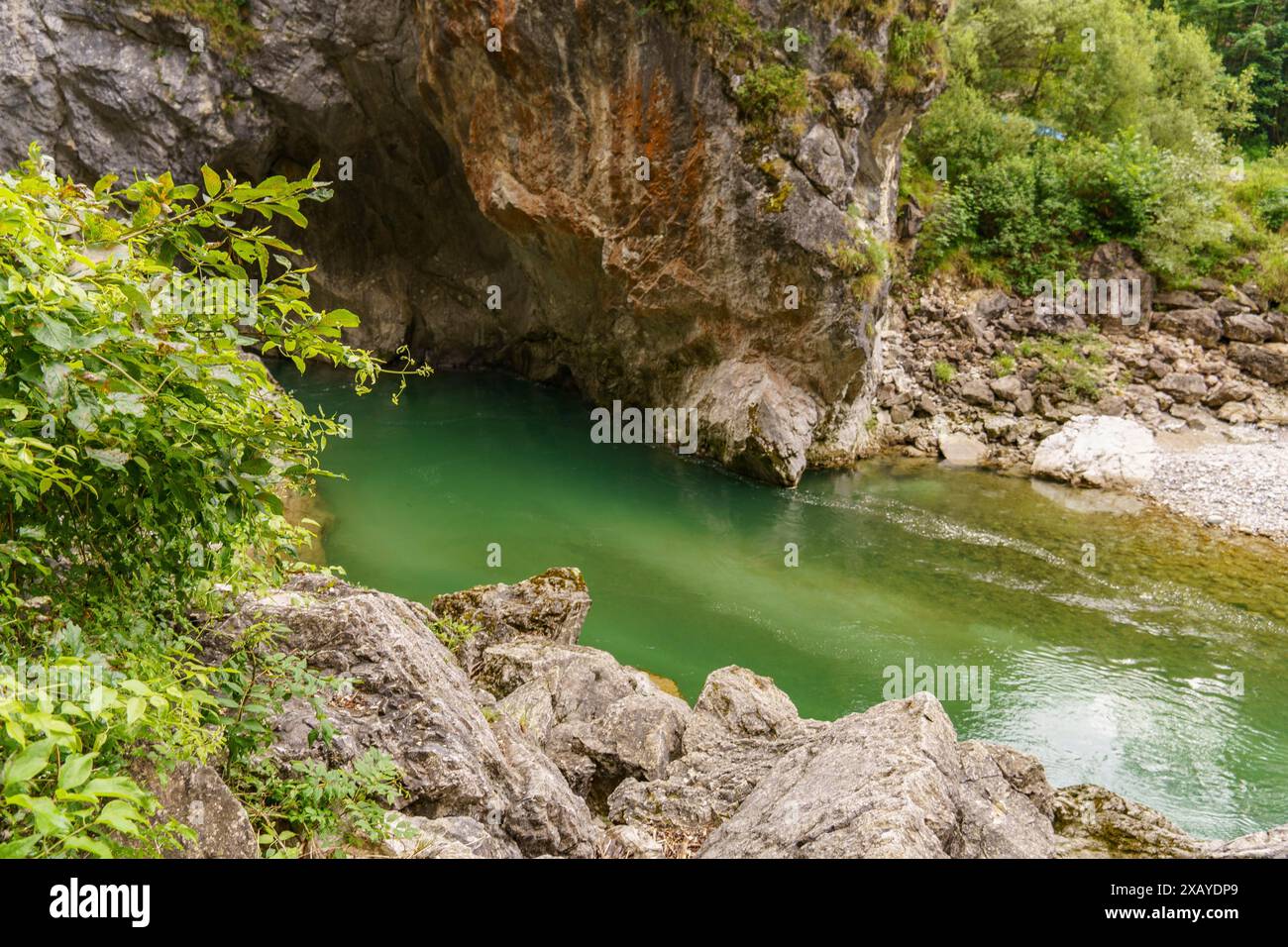 A clear river course flowing through rocky terrain and along lush green ...