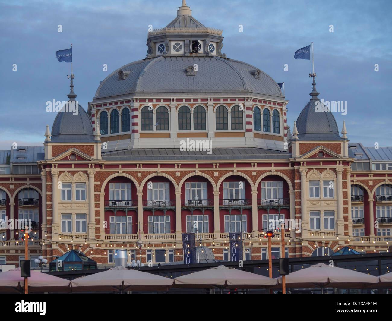 Magnificent historic building with dome and flags in an evening sky ...