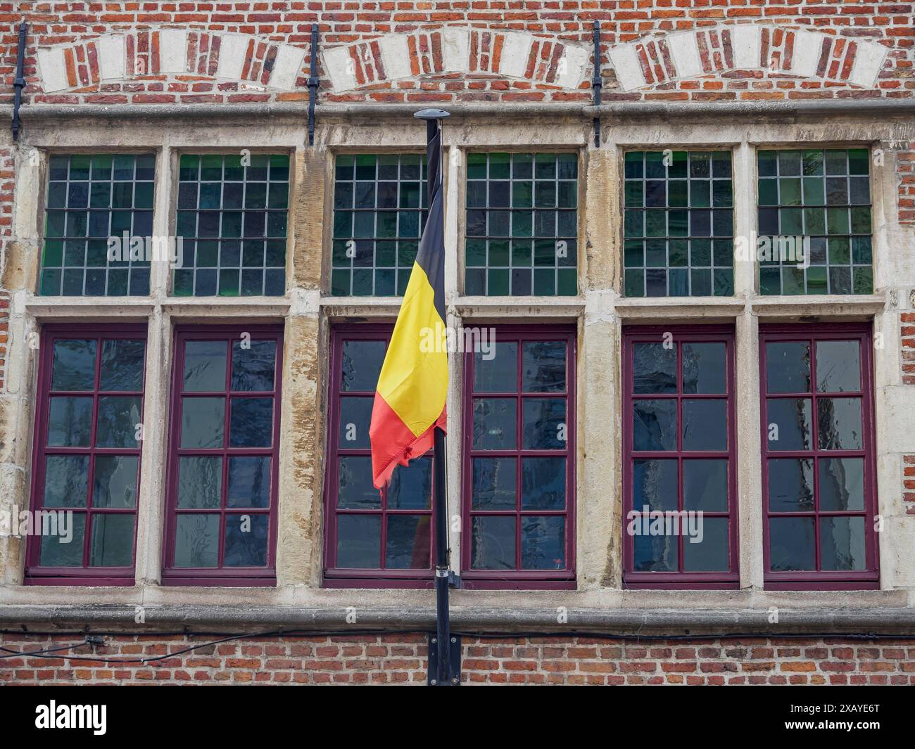 Six windows with Belgian flag on a brick facade, symbolising historical ...