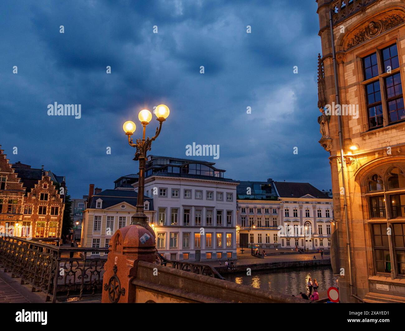 Historic buildings along a river at dusk, illuminated lanterns on the ...