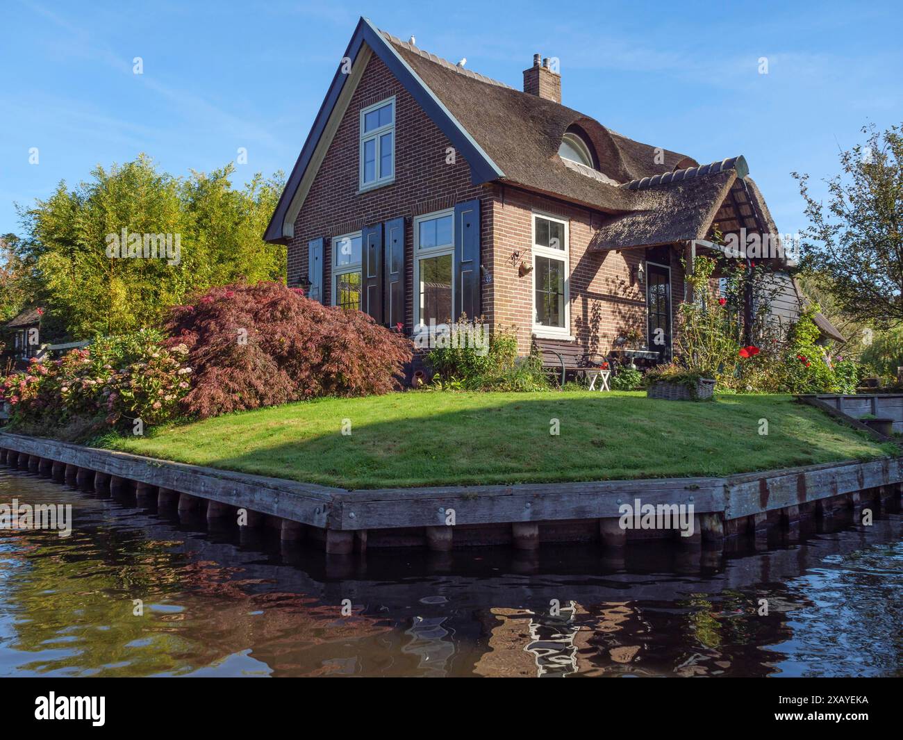 Beautiful rural house with garden and thatched roof on a canal with ...