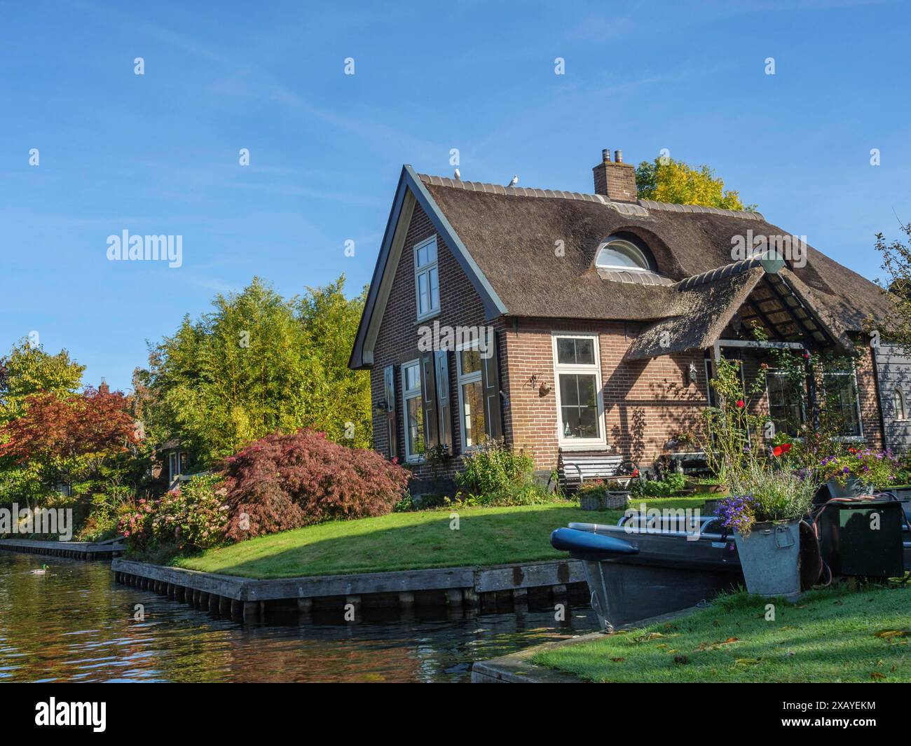 An idyllic house on the canal with a well-tended garden and colourful ...