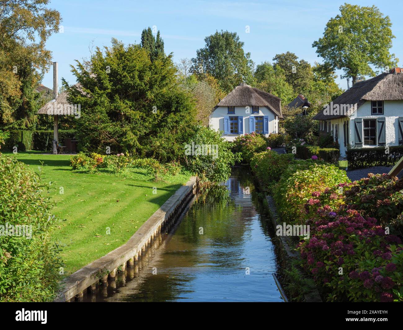 A picturesque canal landscape with traditional houses, manicured ...