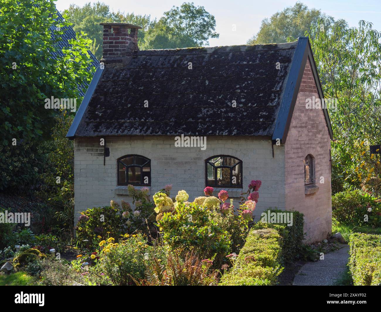 Small, rustic house with a pretty garden full of colourful flowers and ...