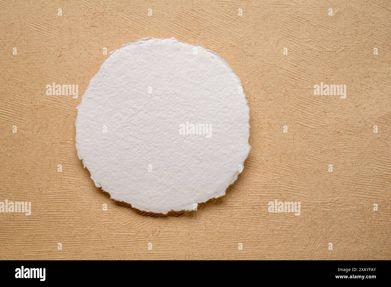 circular sheet of blank white watercolor paper against handmade amate ...