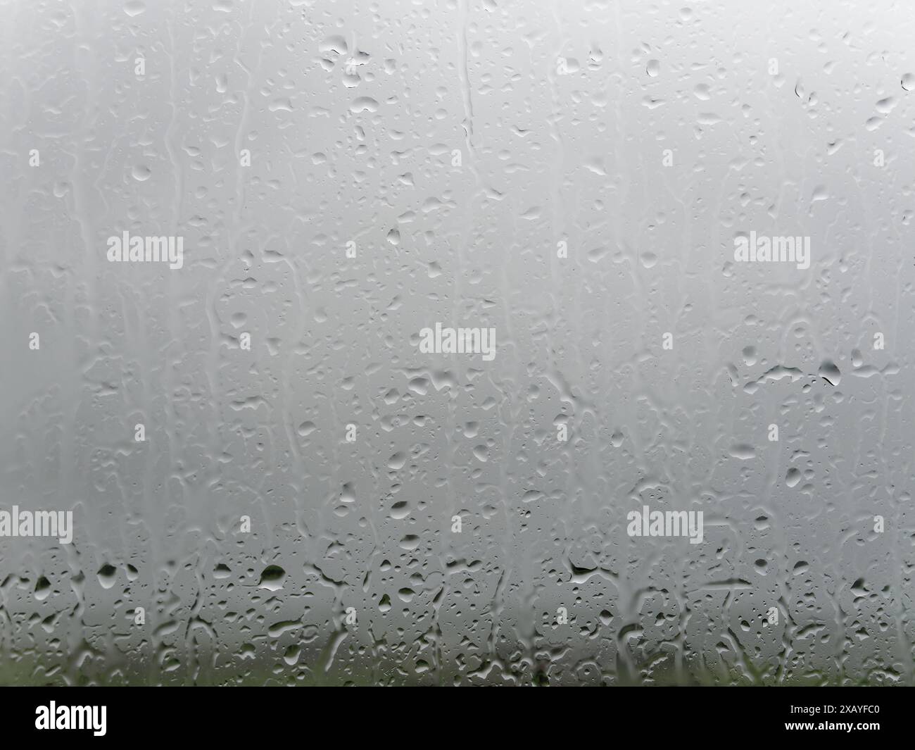 A close-up of a window pane speckled with water droplets, hinting at ...