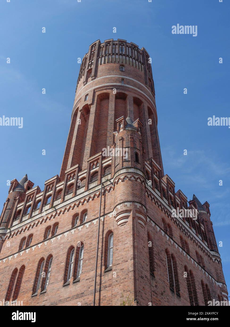 Towering brick tower with decorative elements in front of a clear blue ...
