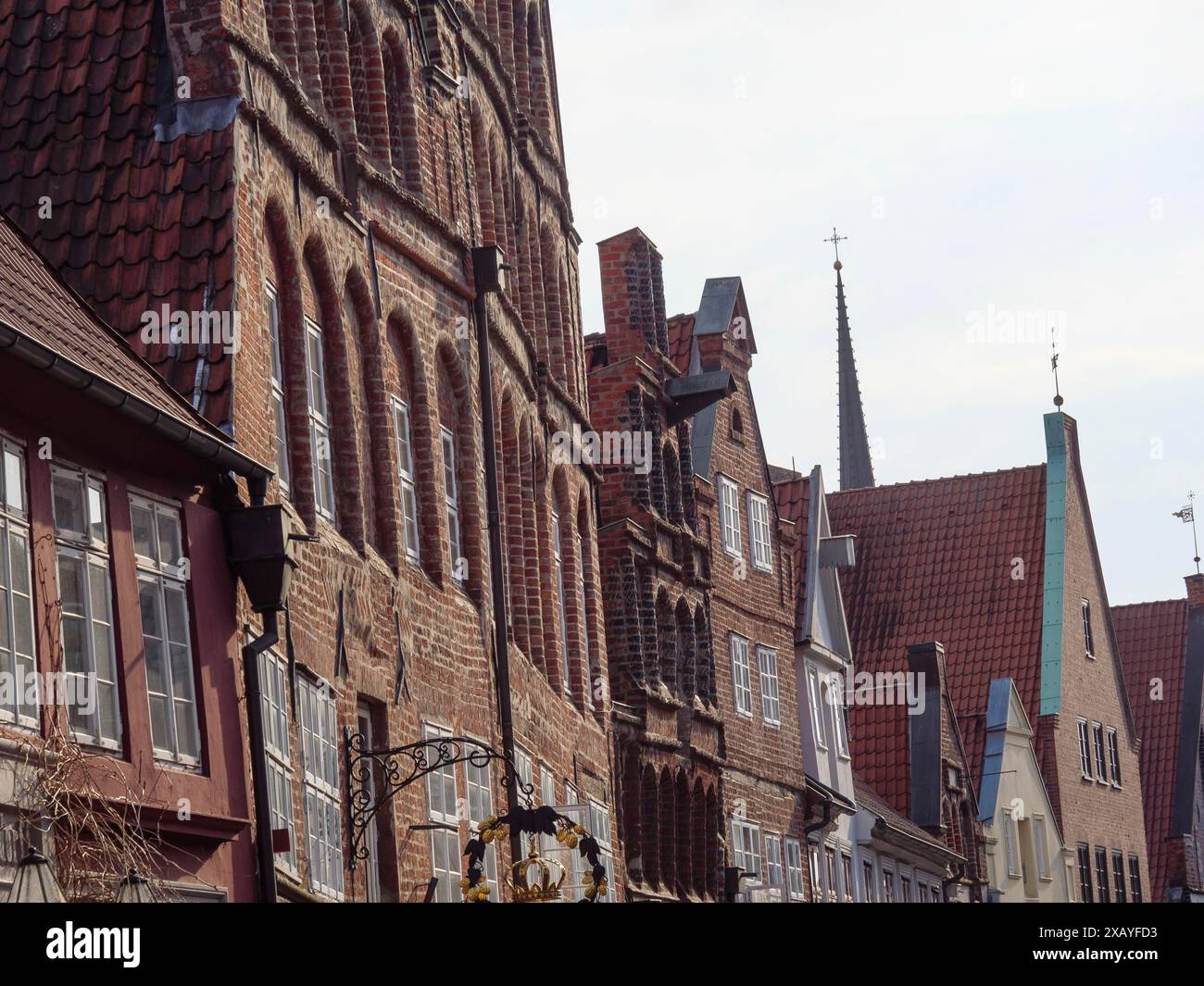Street scene with several historic brick houses, their roofs rising ...