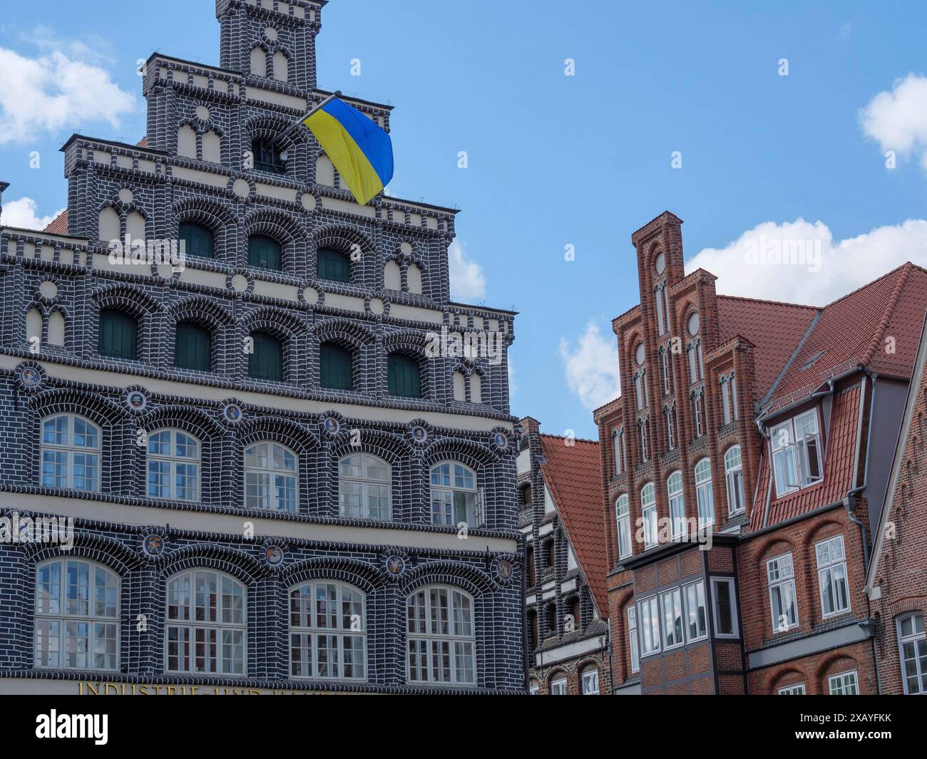 Historic buildings with a national flag and blue sky in a street scene ...