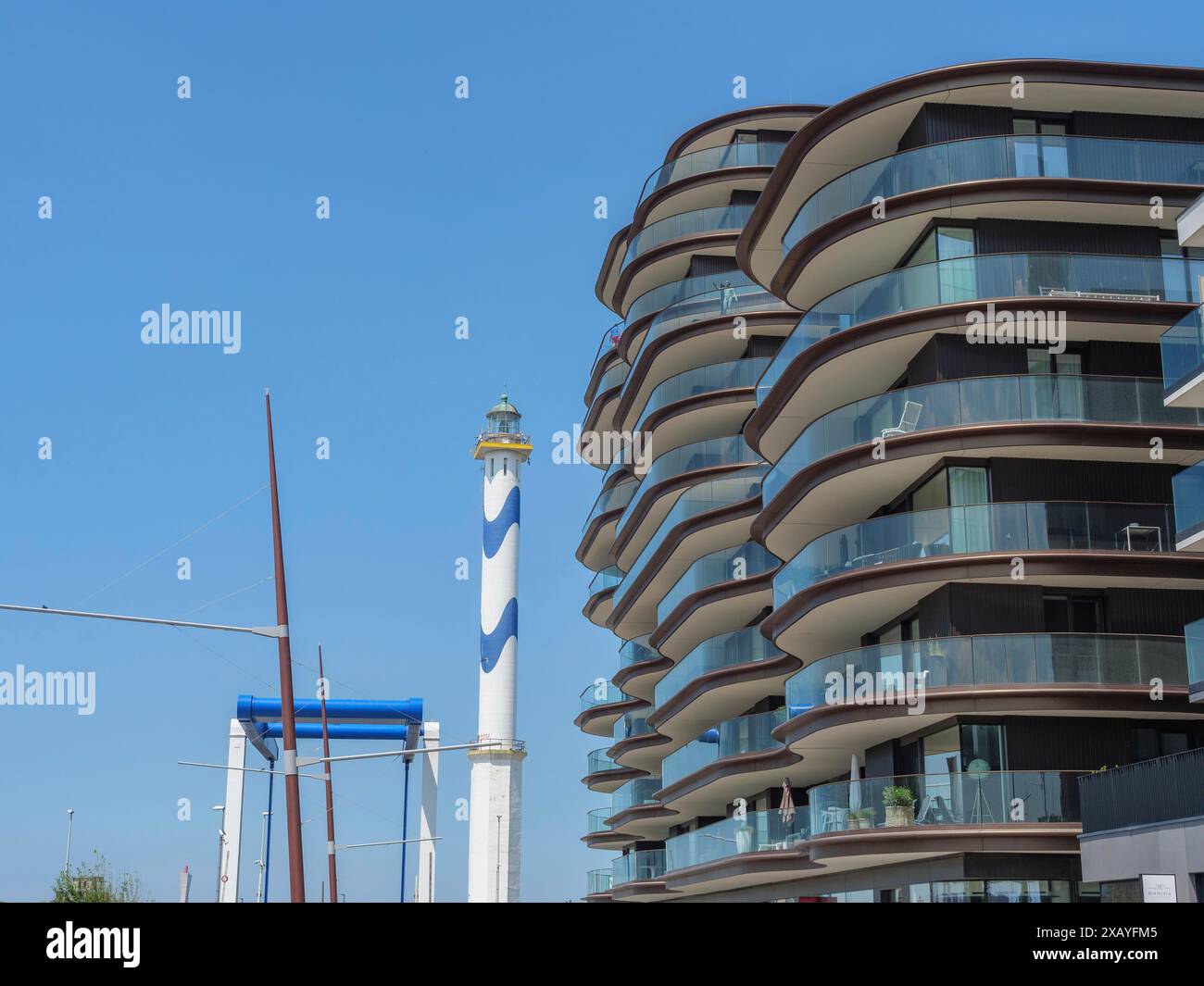 Modern buildings with balconies on a clear day with a lighthouse in the ...