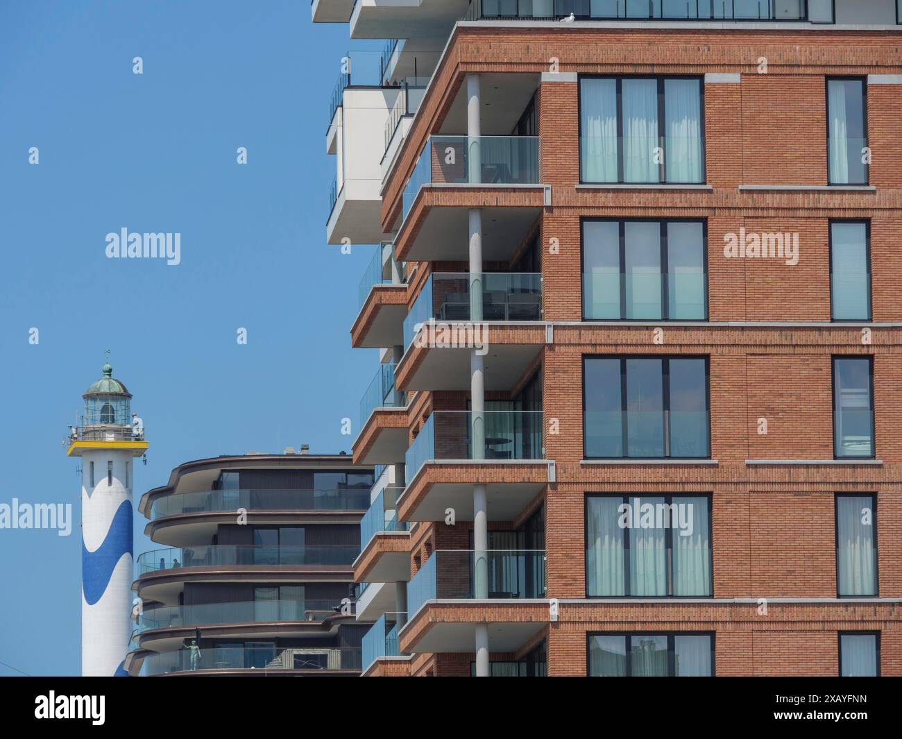 Modern building with balconies and large windows, with a lighthouse in ...