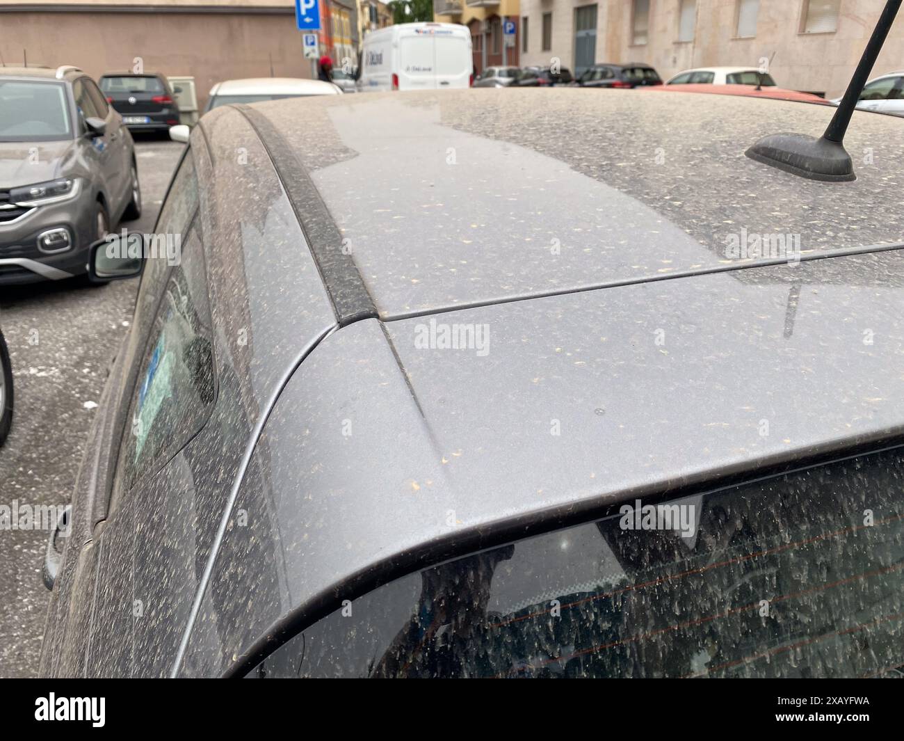 Cremona, Italy - June 9th 2024 Detail of a gray car covered with sand ...