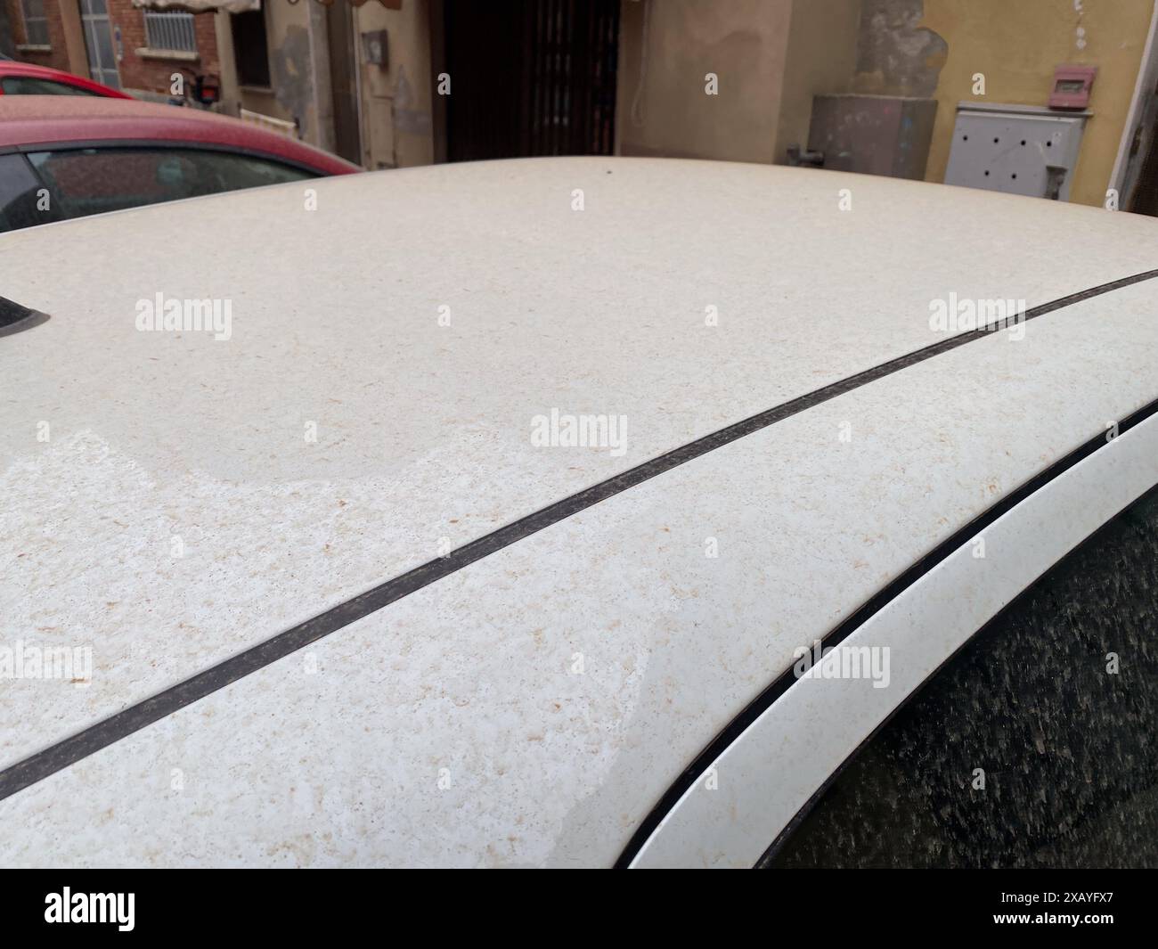 Cremona, Italy - June 9th 2024 White car parked on the street covered ...