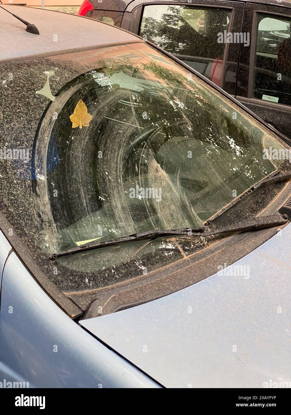 Cremona, Italy - June 9th 2024 Dusty car parked on a city street after ...