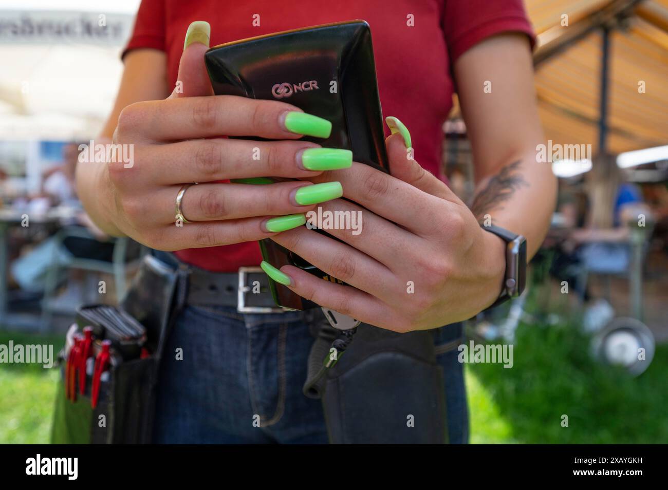 Waitress with long green painted fingernails, cashing up food and ...