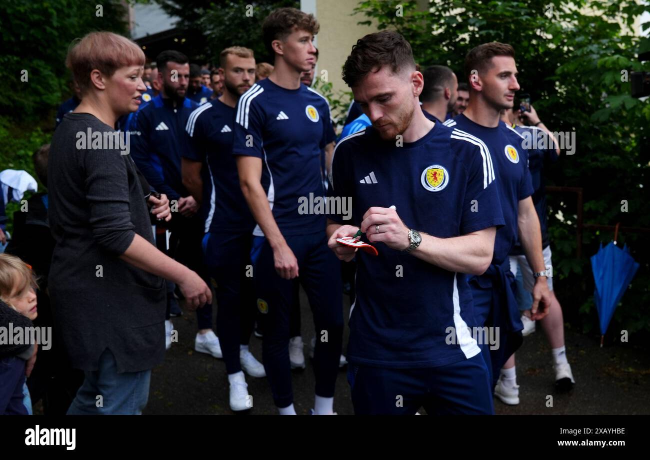 Scotland's Andy Robertson (centre) signs an autograph as he leaves a ...
