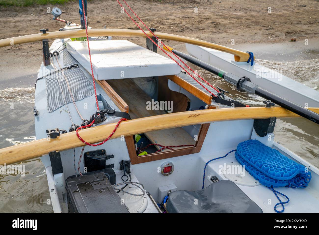 detail of a homebuilt sailing and rowing trimaran boat with a small ...