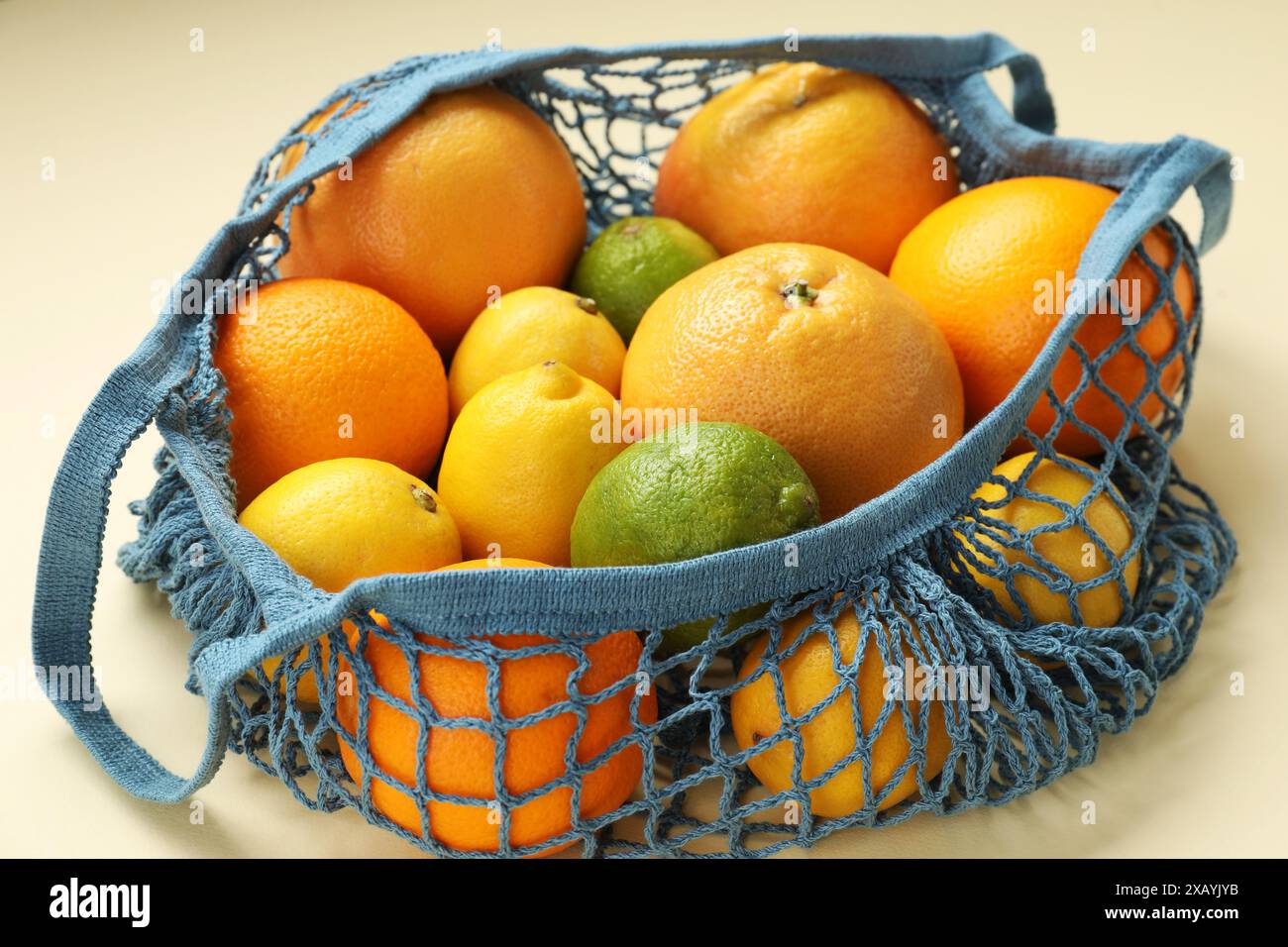 String bag with different fruits on beige background, closeup Stock ...