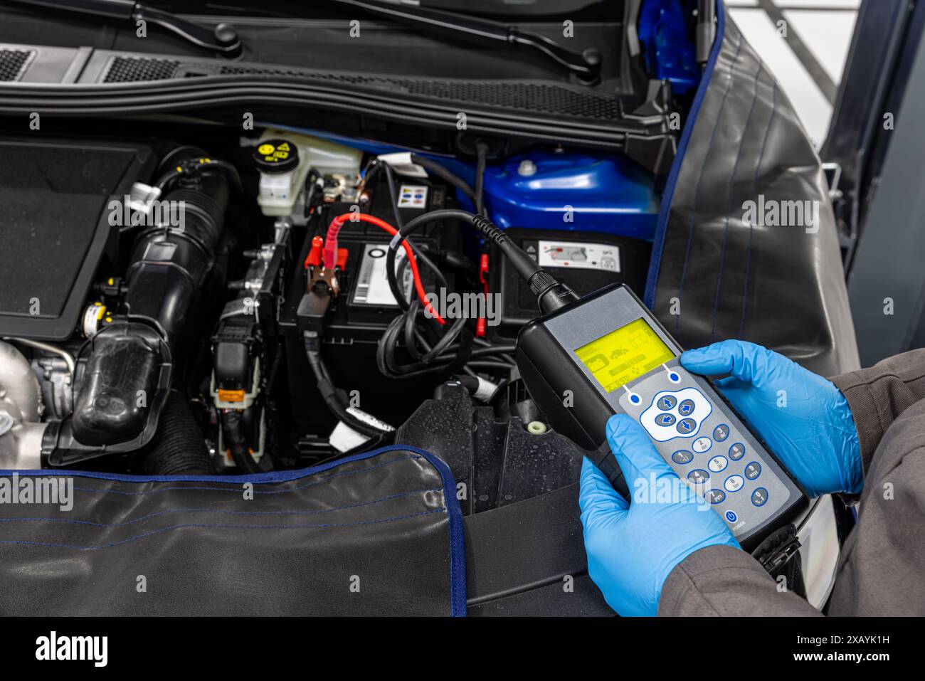 Car master mechanic checking and testing automotive battery with ...