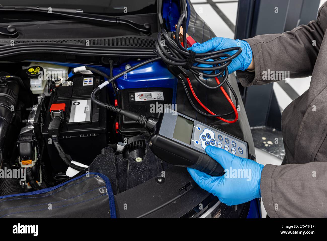 Car master mechanic checking and testing automotive battery with ...