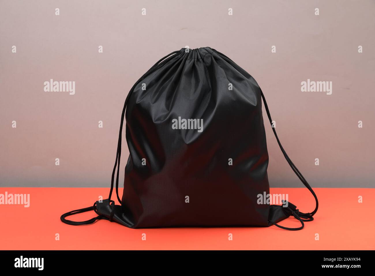 One black drawstring bag on grey background Stock Photo - Alamy