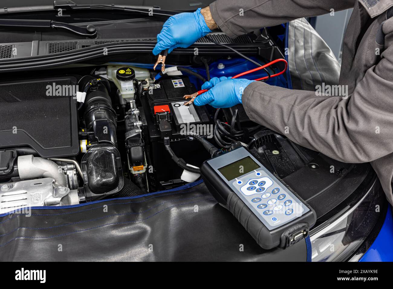Car master mechanic checking and testing automotive battery with ...