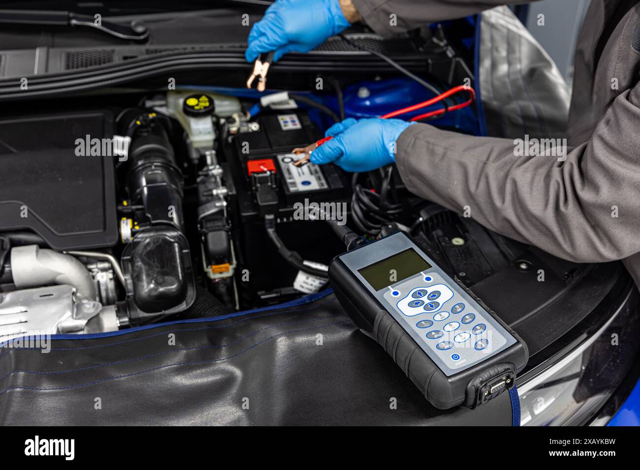 Car master mechanic checking and testing automotive battery with ...