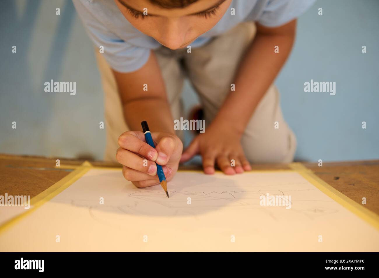 Child engaged in drawing during an art class. The child's hand and ...