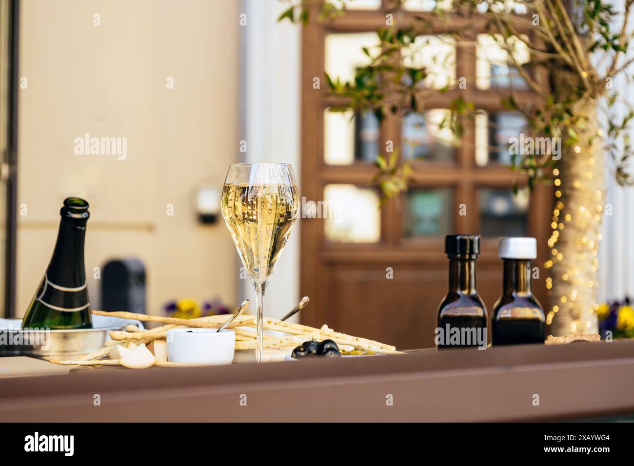 Elegant tall flute of chilled sparkling champagne with different snacks ...